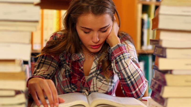 Tired Student Studying in the Library Surrounded by Books Stock Video ...