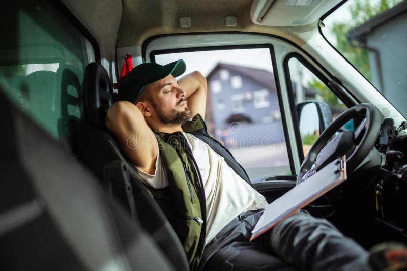 A Tired Truck Driver Takes a Break from Driving and Rests in His Truck ...