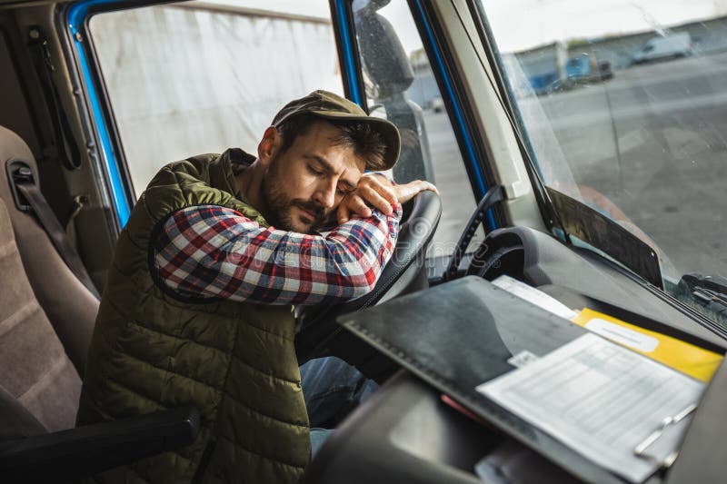 A Tired Young Truck Driver Takes a Break from Driving and Rests in His ...