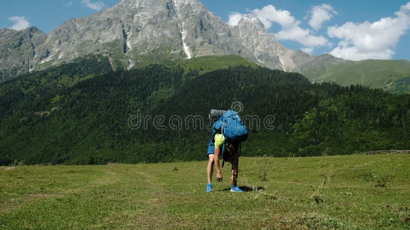 Tired and Weak Tourist with a Heavy Backpack Gets Up from the Ground on ...