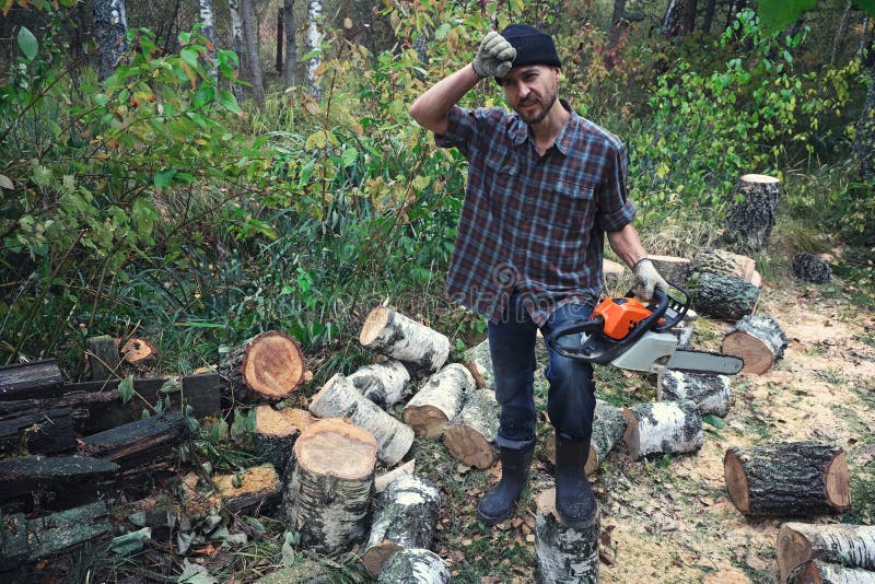 Tired Woodcutter after Hard Work in Forest with Chainsaw. Lumberjack ...