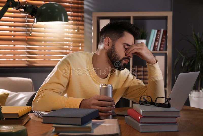 Tired Young Man with Energy Drink Studying Stock Photo - Image of ...