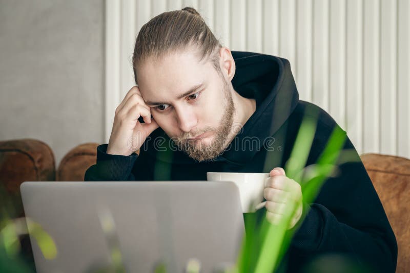 Tired Young Man Working on a Laptop with a Cup of Coffee. Stock Photo ...