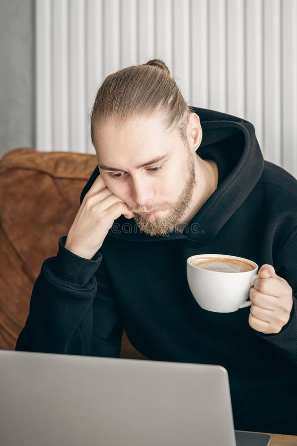 Tired Young Man Working on a Laptop with a Cup of Coffee. Stock Image ...