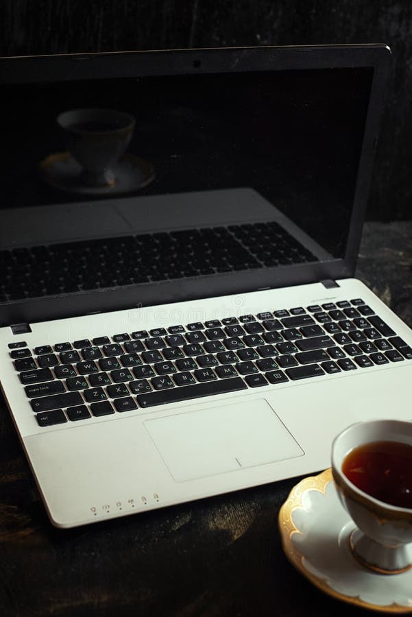 Title: White Laptop with a Cup of Delicious Tea while Working at Home ...