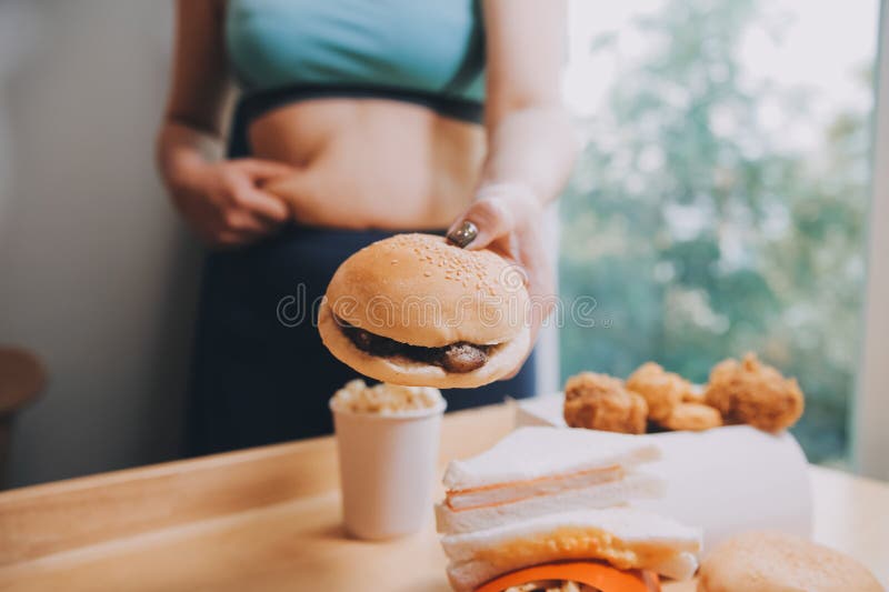 To Eat or Not. Cheerless Plump Woman Looking at the Burger while ...