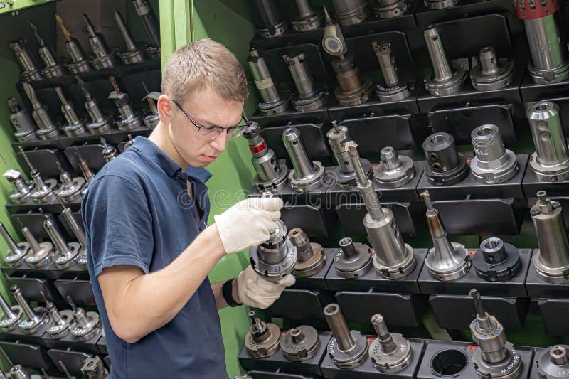 To Operate a CNC Machine, a Worker Selects and Inspects the Required ...