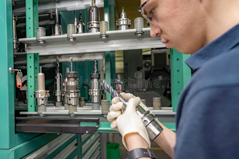 To Operate a CNC Machine, a Worker Selects and Inspects the Required ...