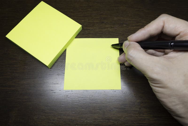 To Write Something by he Black Pen on the Yellow Paper Note. Stock ...