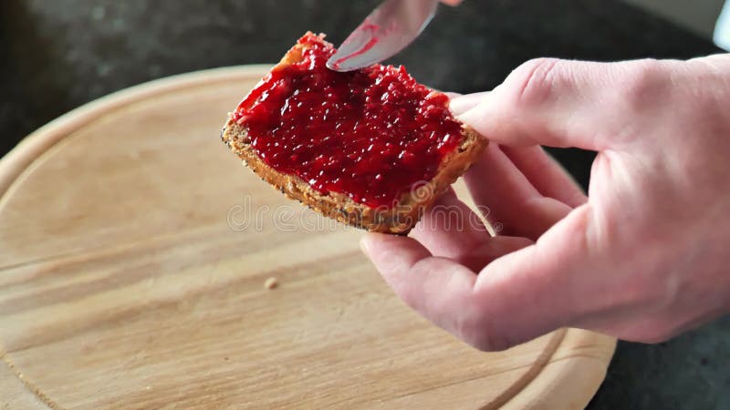 Toast with Jam. Hands Spread Jam on Bread on the Kitchen Table.View ...