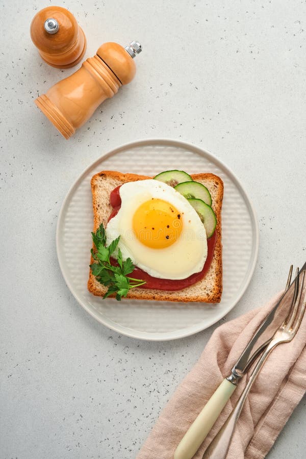 Toast with Tomatoes Ketchup, Cucumber and Fried Egg on White Plate, Top ...