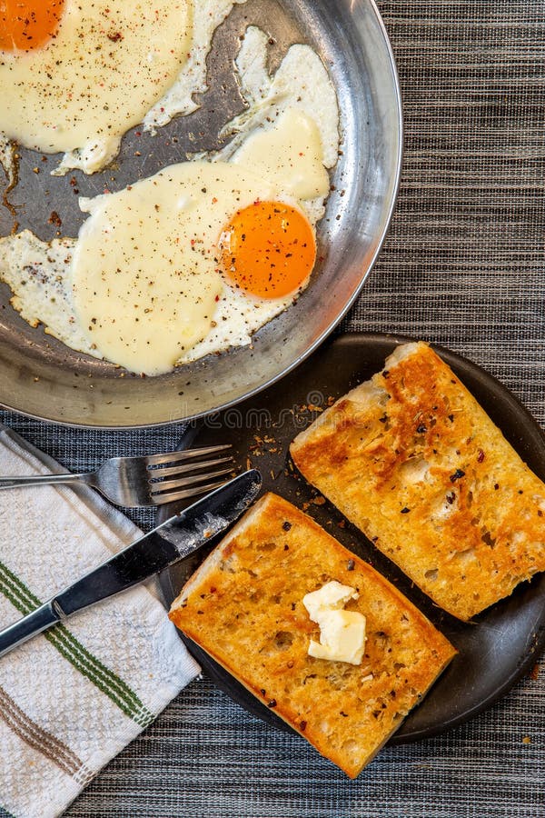 Toasted Bread with Butter and Fried Eggs on a Rustic Table Stock Image ...