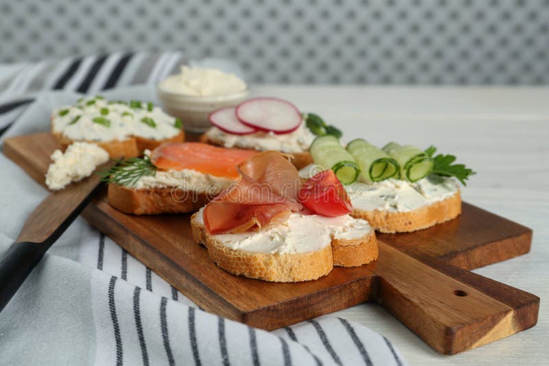 Toasted Bread with Cream Cheese and Different Toppings on White Wooden ...