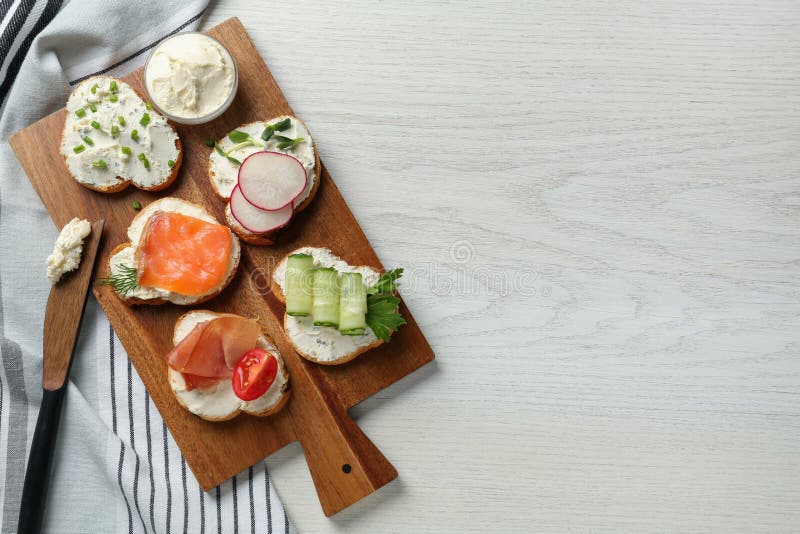 Toasted Bread with Cream Cheese and Different Toppings on White Wooden ...