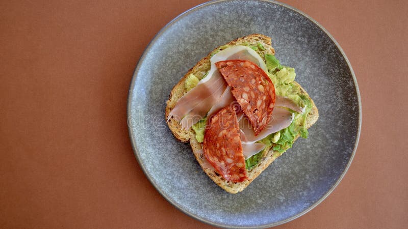 Toasted Multi Grain Bread with Smashed Avocado and Hot Italian Salami ...