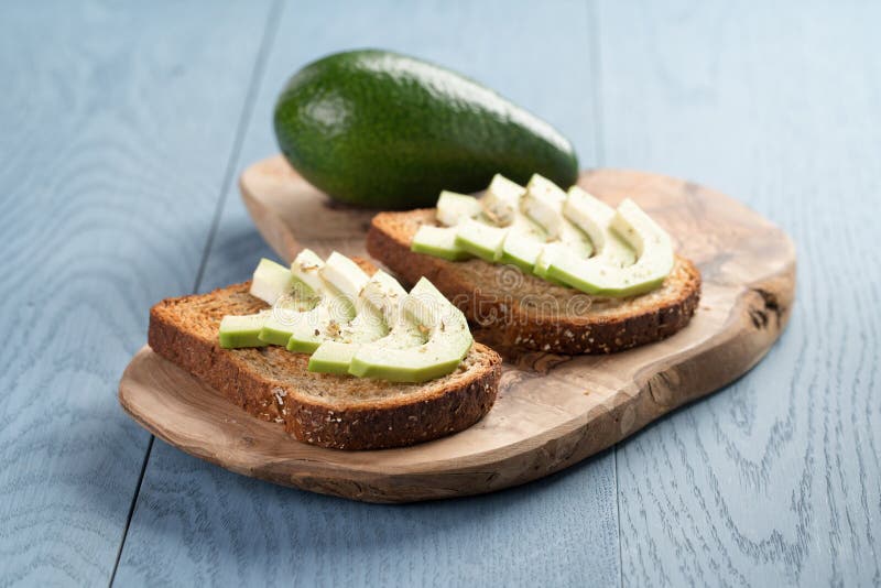 Toasted Rye Bread with Sliced Avocado and Herbs Stock Photo - Image of ...