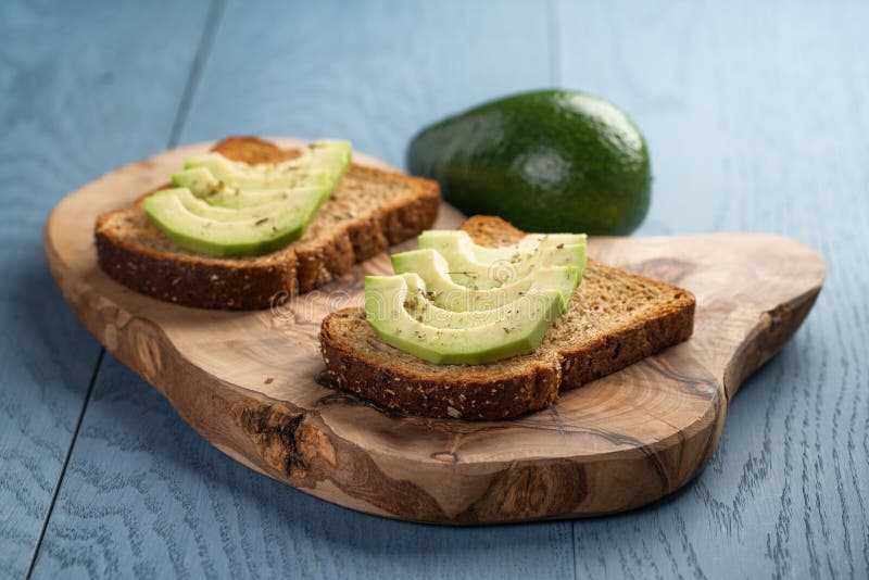 Toasted Rye Bread with Sliced Avocado and Herbs Stock Photo - Image of ...
