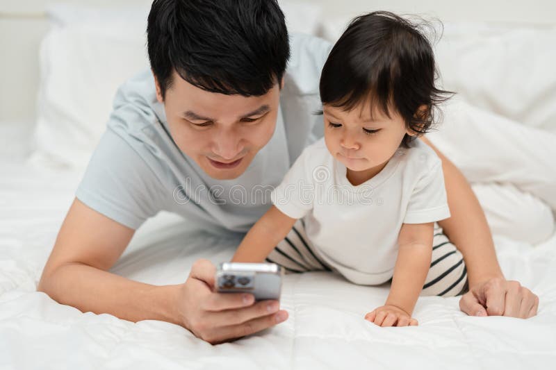 Toddler Baby with Father Using and Watching Smartphone on Bed Stock ...