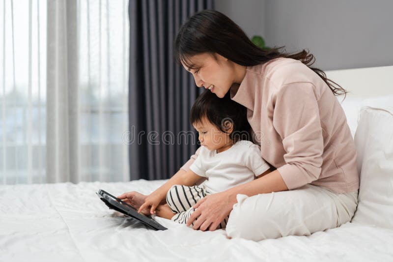 Toddler Baby with Mother Watching Digital Tablet Pc on Bed Stock Photo ...