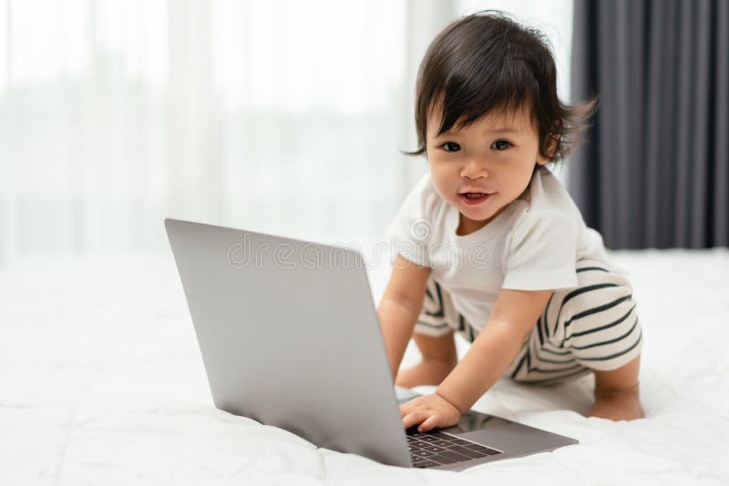 Toddler Baby Typing on Laptop Computer on Bed Stock Photo - Image of ...