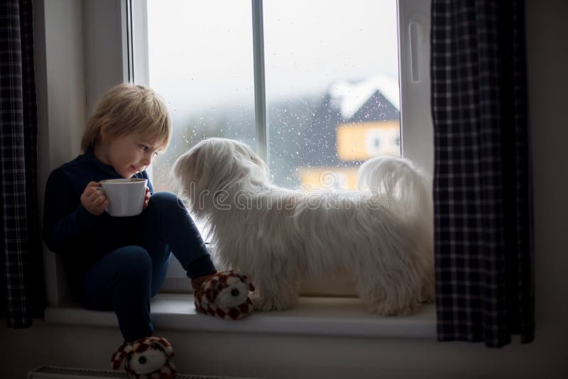 Toddler Child, Sitting on the Window, Watching the Snow Falling Stock ...