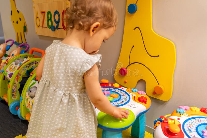 Toddler Exploring Colorful Playroom with Activity Table. Concept of ...