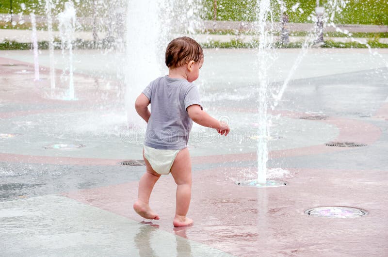 Toddler Exploring a Splash Pad Stock Photo - Image of horizontal, young ...