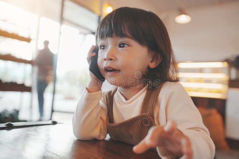 Toddler Girl Talking with Smartphone at Cafe Stock Image - Image of ...