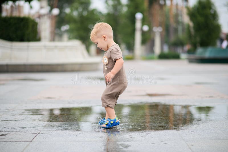 Toddler Playing in a Rain Puddle Outdoors Stock Photo - Image of cute ...