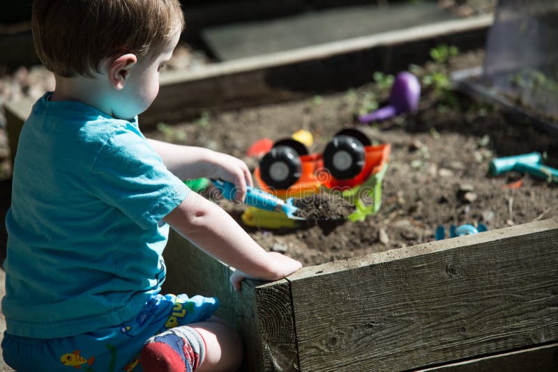 Toddler playing on sandbox stock photo. Image of ground - 92266890