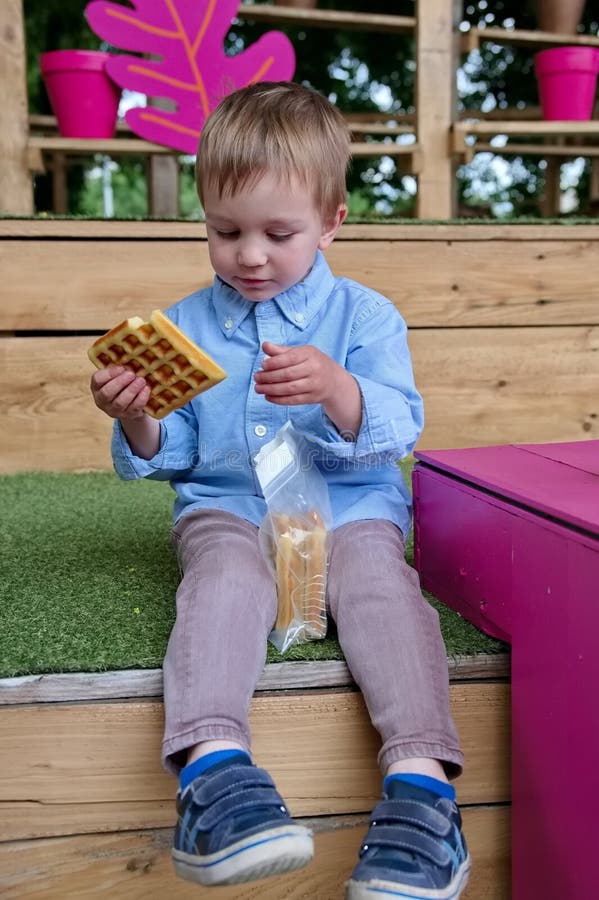 Toddler Sitting on the Bench and Eating Cookies Stock Photo - Image of ...