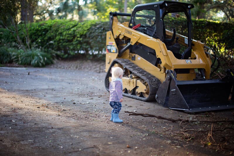 Toddler Stand Beside Front Loader Picture. Image: 109916476