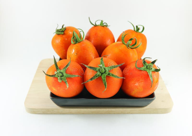Tomato in Black Dish on on Wood Chopping Block White Background Stock ...