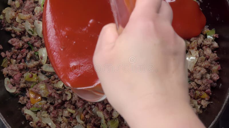Tomato Paste is Poured into a Frying Pan on Which Ground Beef is Fried ...