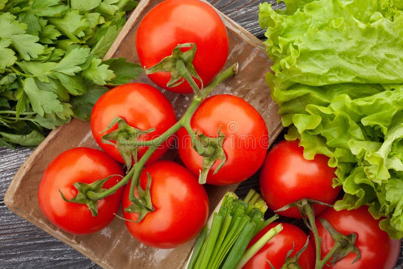 Tomato on a plate on wood stock image. Image of spring - 254628045