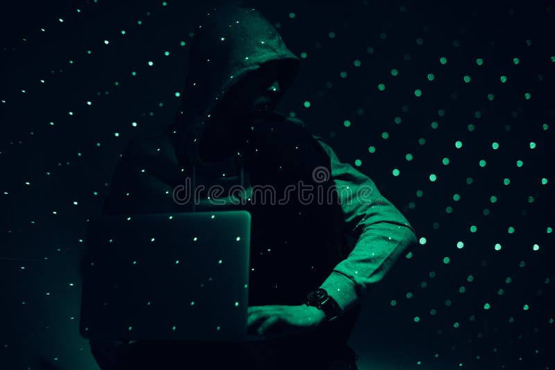 Silhouette Of A Hacker In A Hood Against A Background Of Glowing Green Binary Code Hacking Of