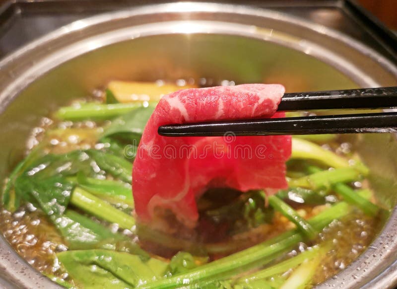 Tong beef into shabu pot stock image. Image of slice - 174047351