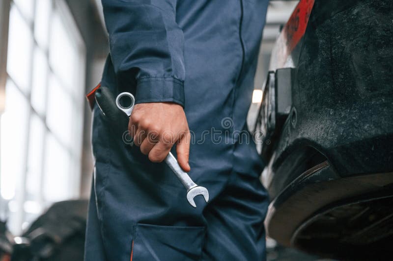 Tool in Hand of a Worker that is in Blue Uniform Near Car Stock Image ...