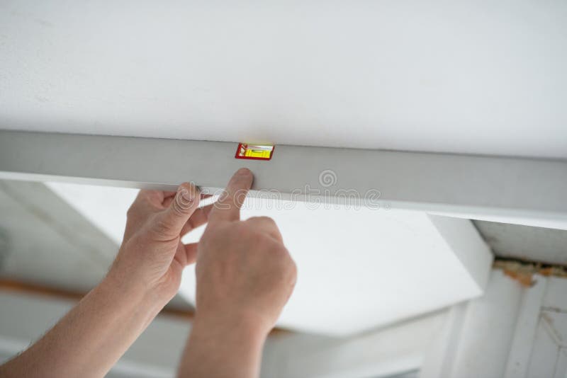 Tool Level in Men S Hands and a Flat Horizontal Surface of the Ceiling ...