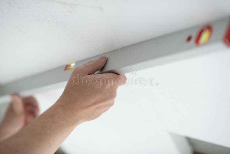 Tool Level in Men S Hands and a Flat Horizontal Surface of the Ceiling ...