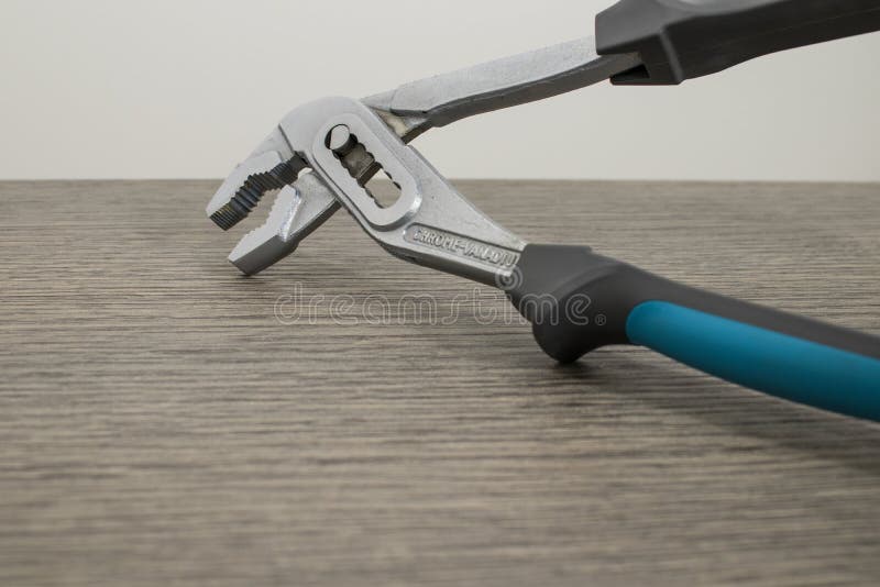 Tools, Blue Pipe Wrench on a Decorated Wood Table Stock Image - Image ...