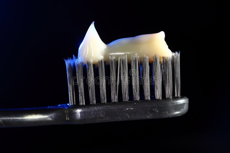 Toothbrush on a Black Background with Cream Colored Paste Stock Photo ...