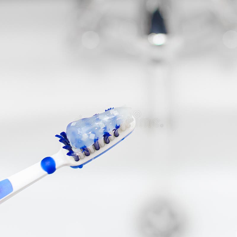 Toothbrush Blue and White with Toothpaste on the Background of Tap ...