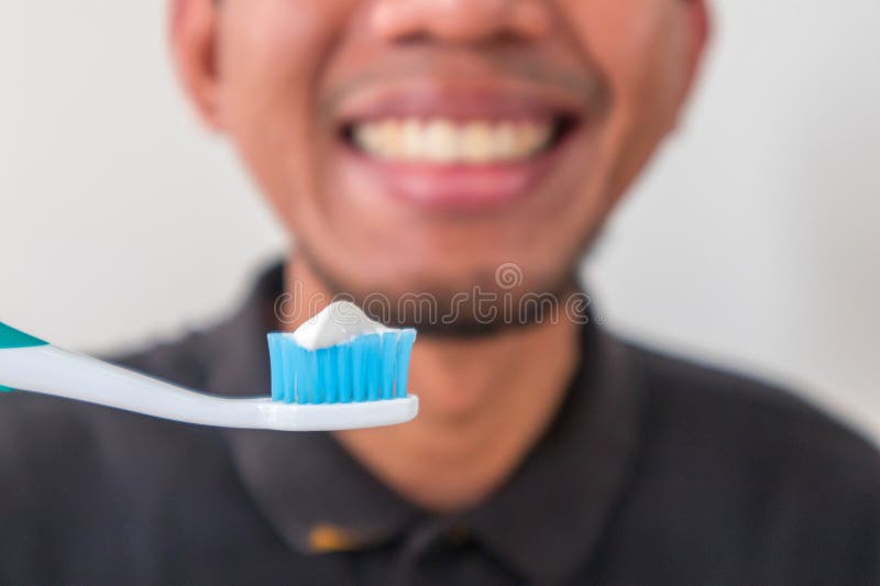 Toothbrush and a Smiling Man Showing Teeth in Background Stock Photo ...