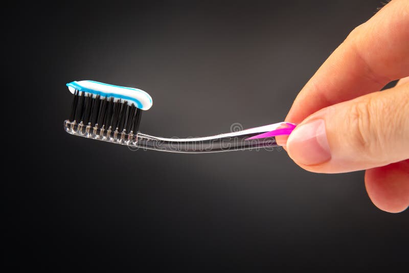 Toothbrush with Toothpaste for Cleaning Teeth on a Dark Background ...