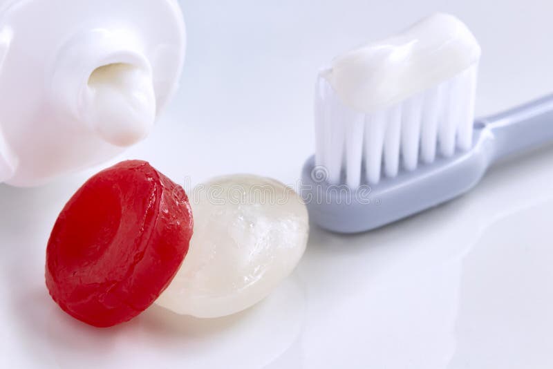 Toothbrush, Toothpaste Tube and Candy on the White Table. Stock Photo ...