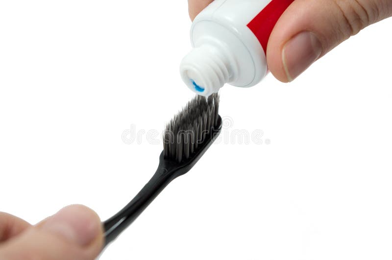 A Toothbrush and Tube of Toothpaste in a Hand Isolated on White ...