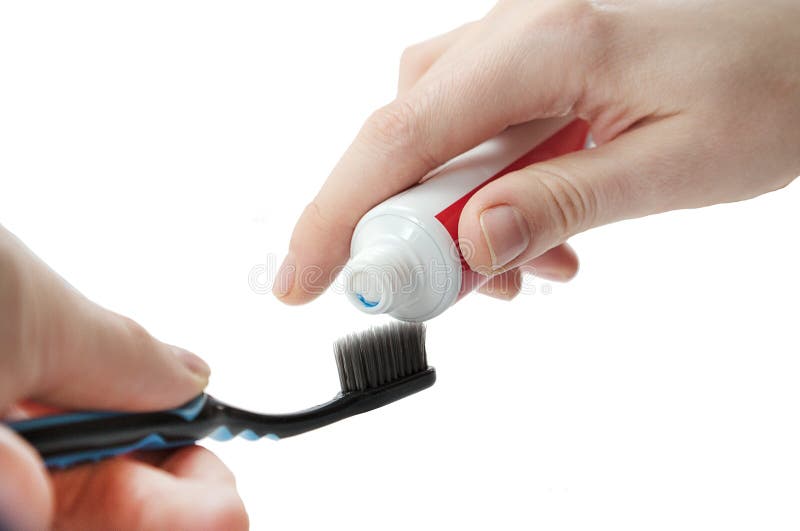 A Toothbrush and Tube of Toothpaste in a Hand Isolated on White ...