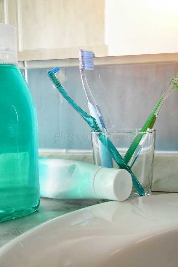 Toothbrushes Toothpaste and Mouthwash on a Sink Vertical Stock Image ...