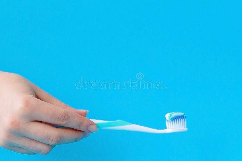 Toothpaste on a Toothbrush Close-up on a Blue Light Background Stock ...